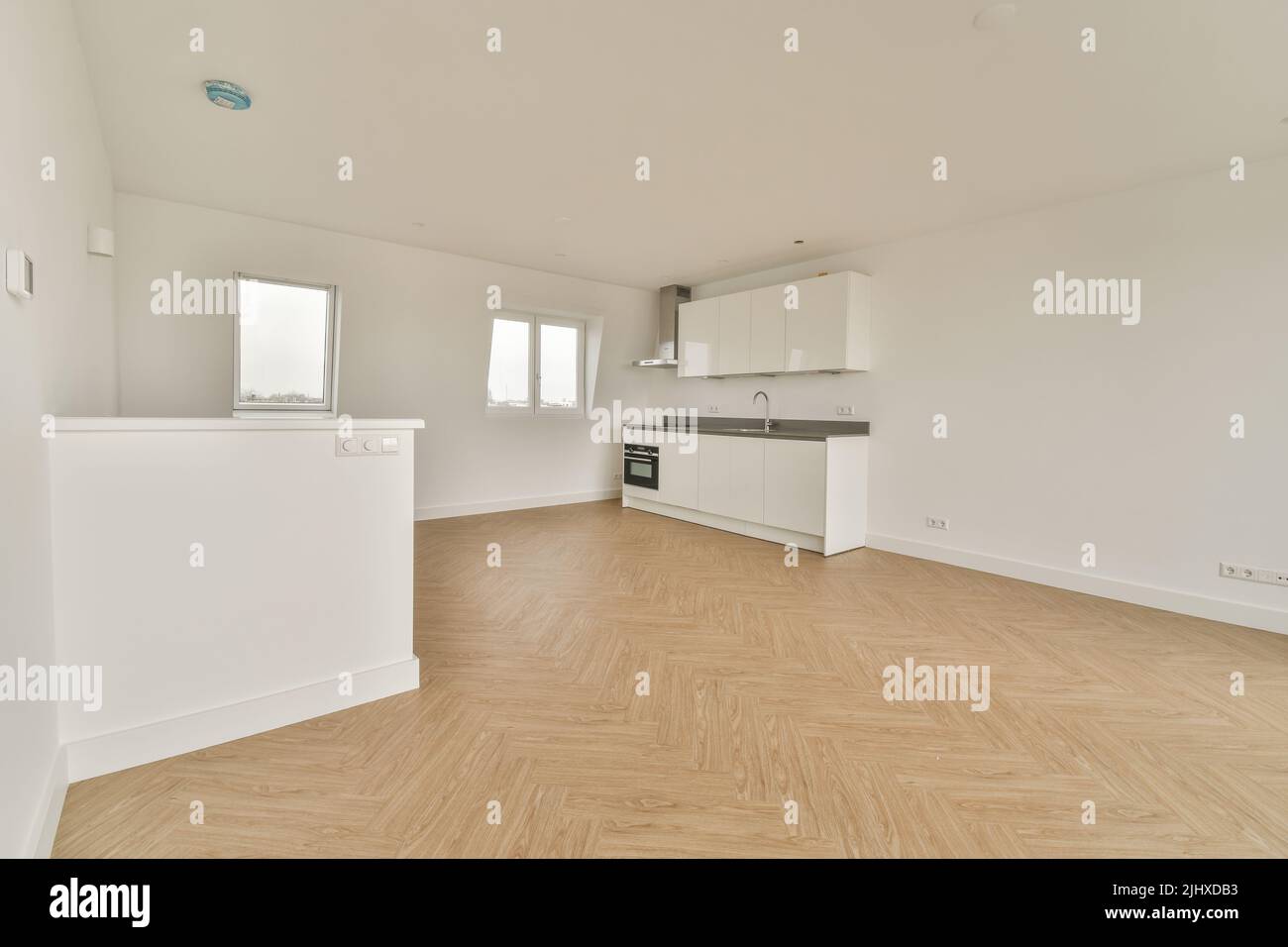 Interior of empty white kitchen with windows and wooden parquet floor ...