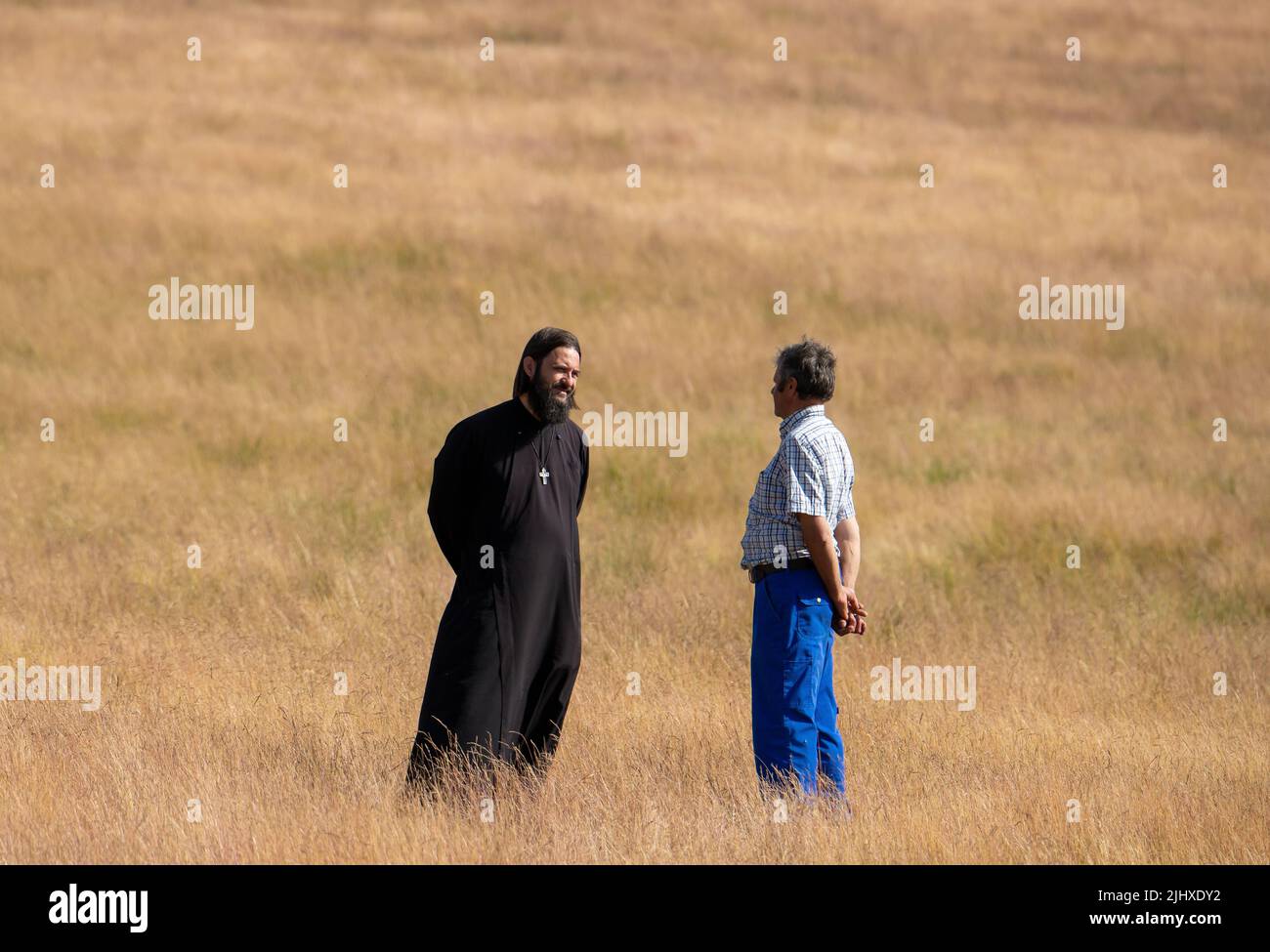A parishioner confessing to a priest in a rural area, nature Stock ...