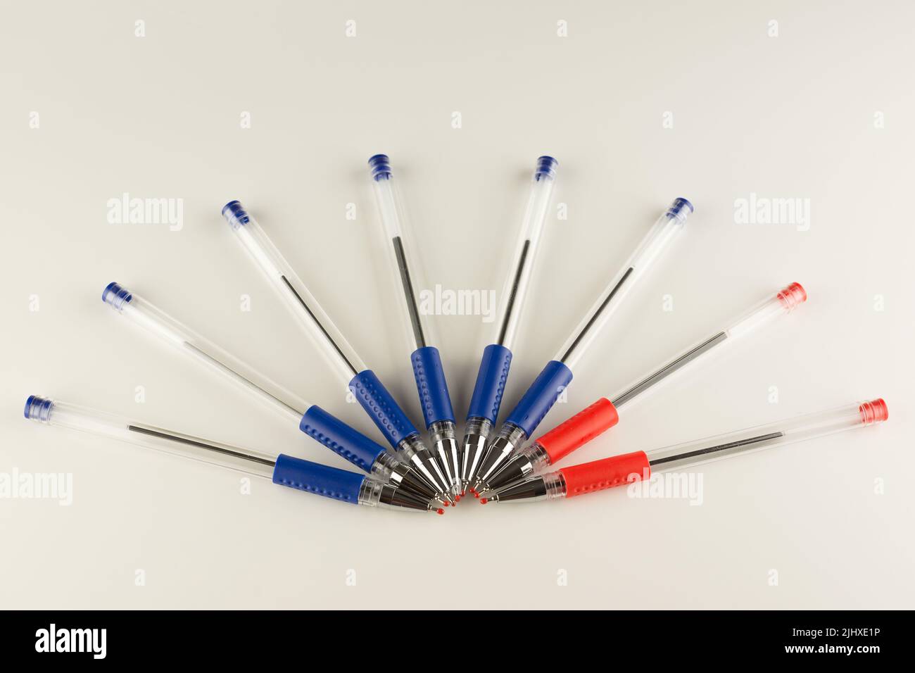 set of blue ballpoint pens lined up by an arc on a white background ...