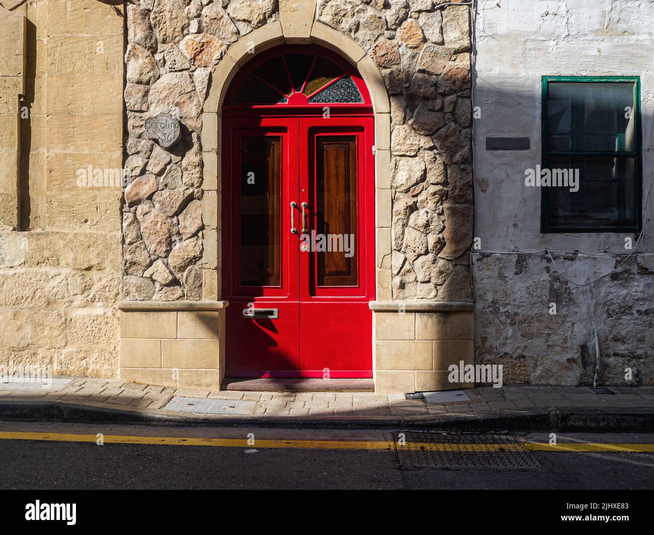 A view of the exterior of a building with a red door Stock Photo - Alamy