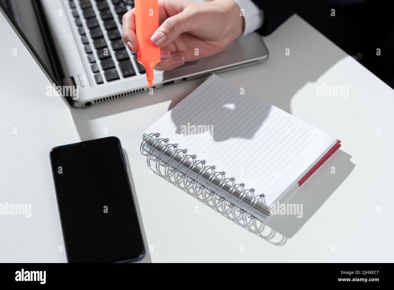 Businesswoman Writing In Notebook With Marker On Desk With Mobile Phone ...