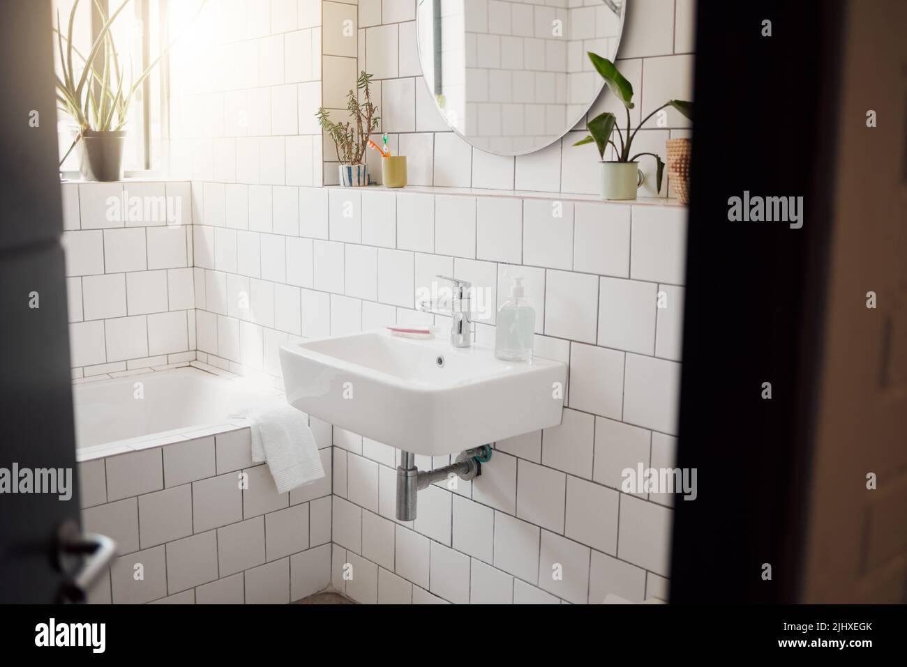 A clean and tidy bathroom inside a house. A basin, bath, with ceramic ...