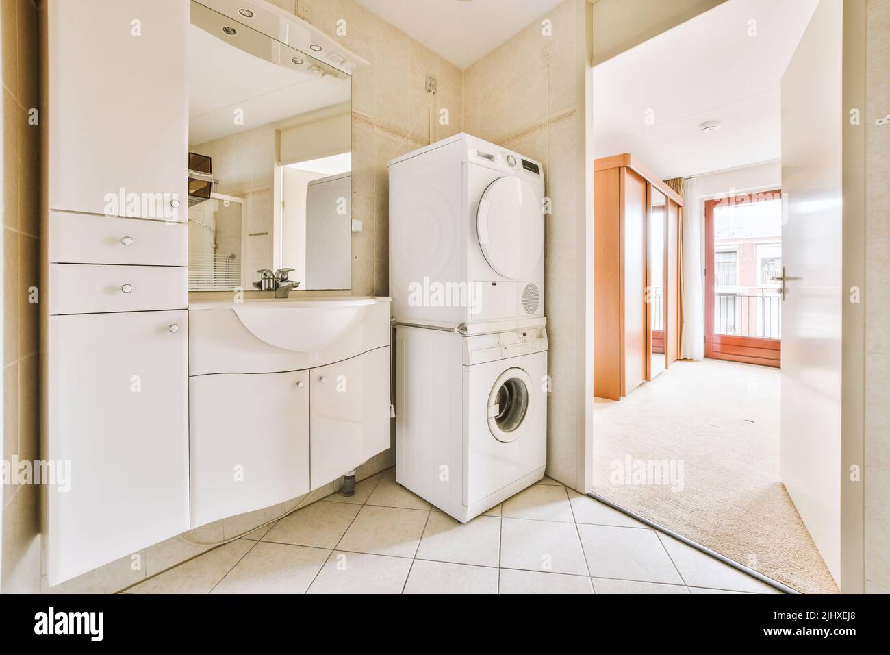 Sink with tap and liquid soap hanging on tiled wall under mirror in ...