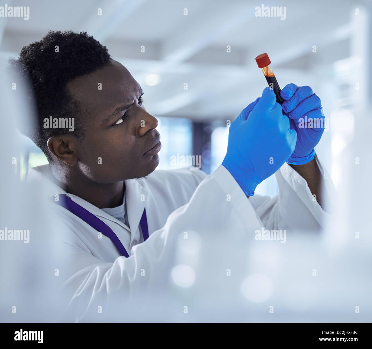 The blood holds the secrets. a young male scientist analysing a blood ...