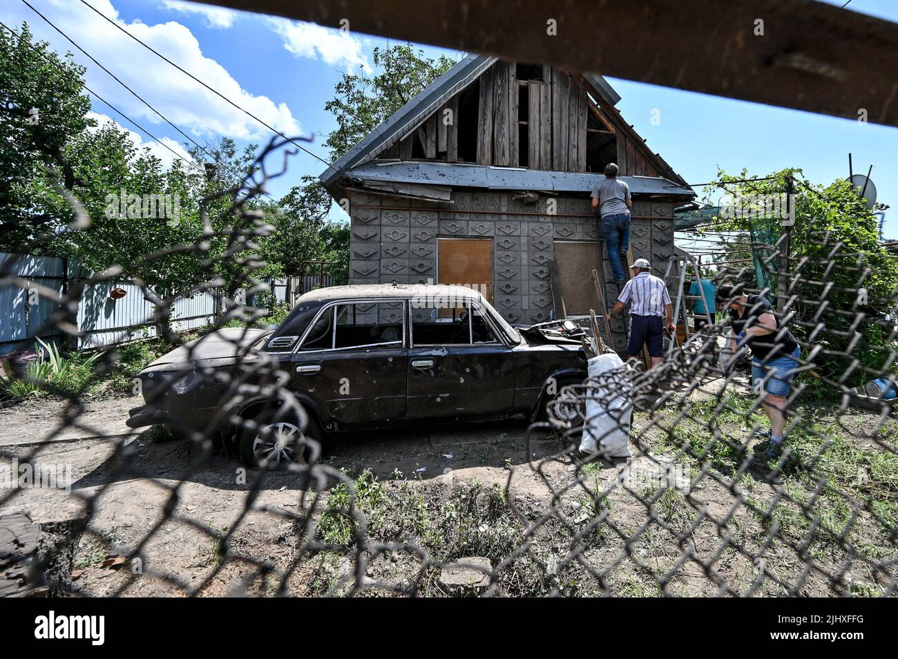 People assess the damage done to a house by Russian shelling, Nikopol ...