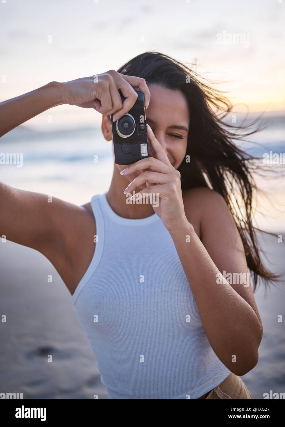 Give me a smile. a woman taking a picture with her camera while at the ...