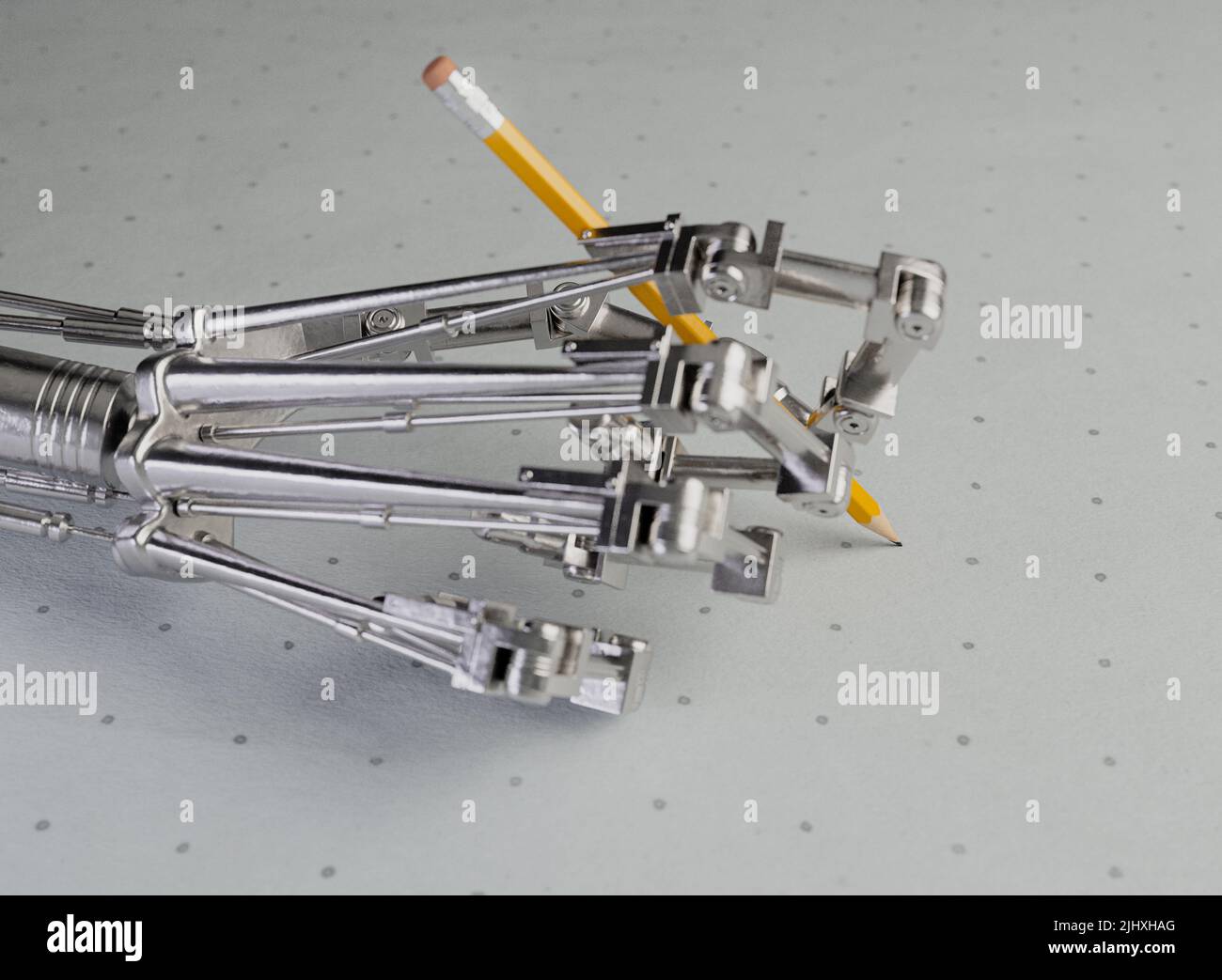A mechanical robotic metal hand drawing or writing with a pencil on a ...