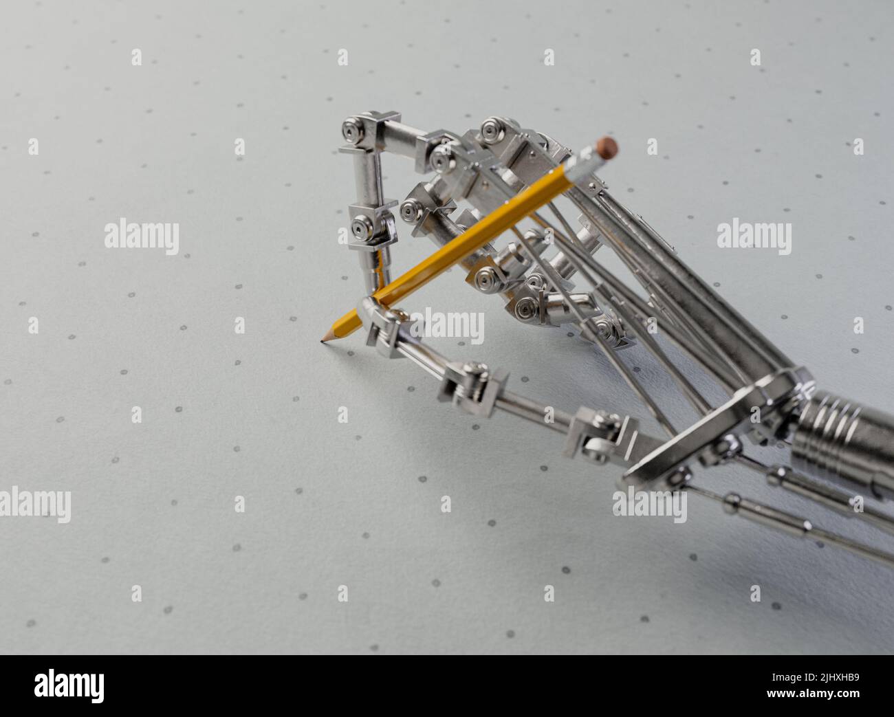 A mechanical robotic metal hand drawing or writing with a pencil on a ...