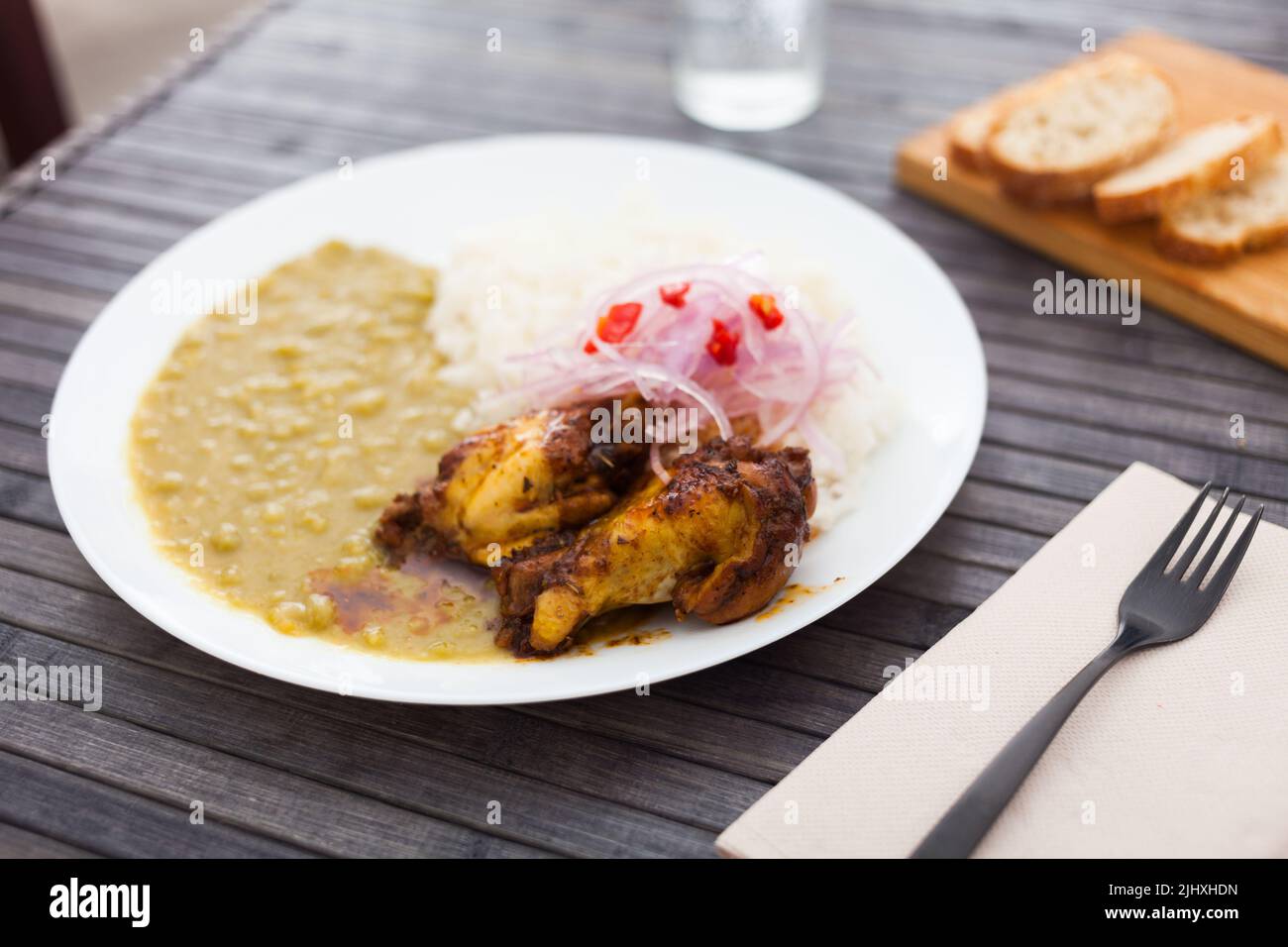 Peruvian dish. chicken wings with pea puree, rice and pickled onions ...