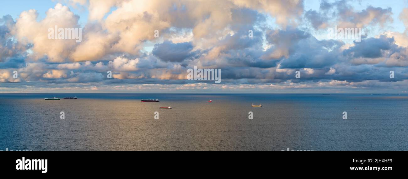 Moody sky over container ships swimming on sea gulf, aerial landscape ...