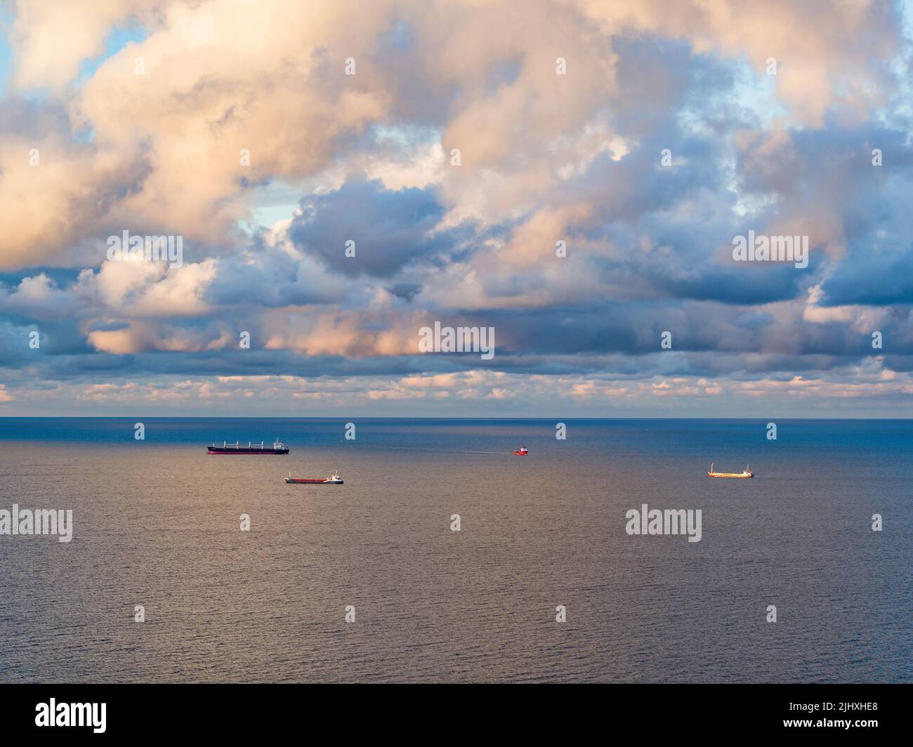Moody sky over container ships swimming on sea gulf, aerial landscape ...