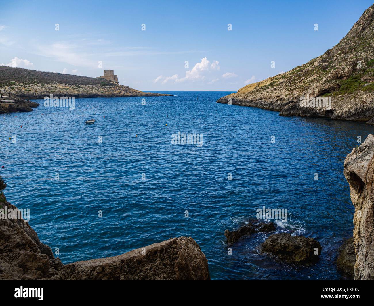An aerial view of sea surrounded by cliffs in background of Xlendi ...
