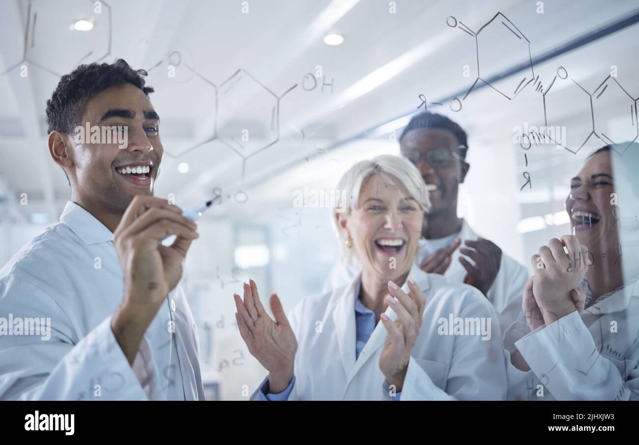 Diverse group of happy scientists clapping hands while writing and ...