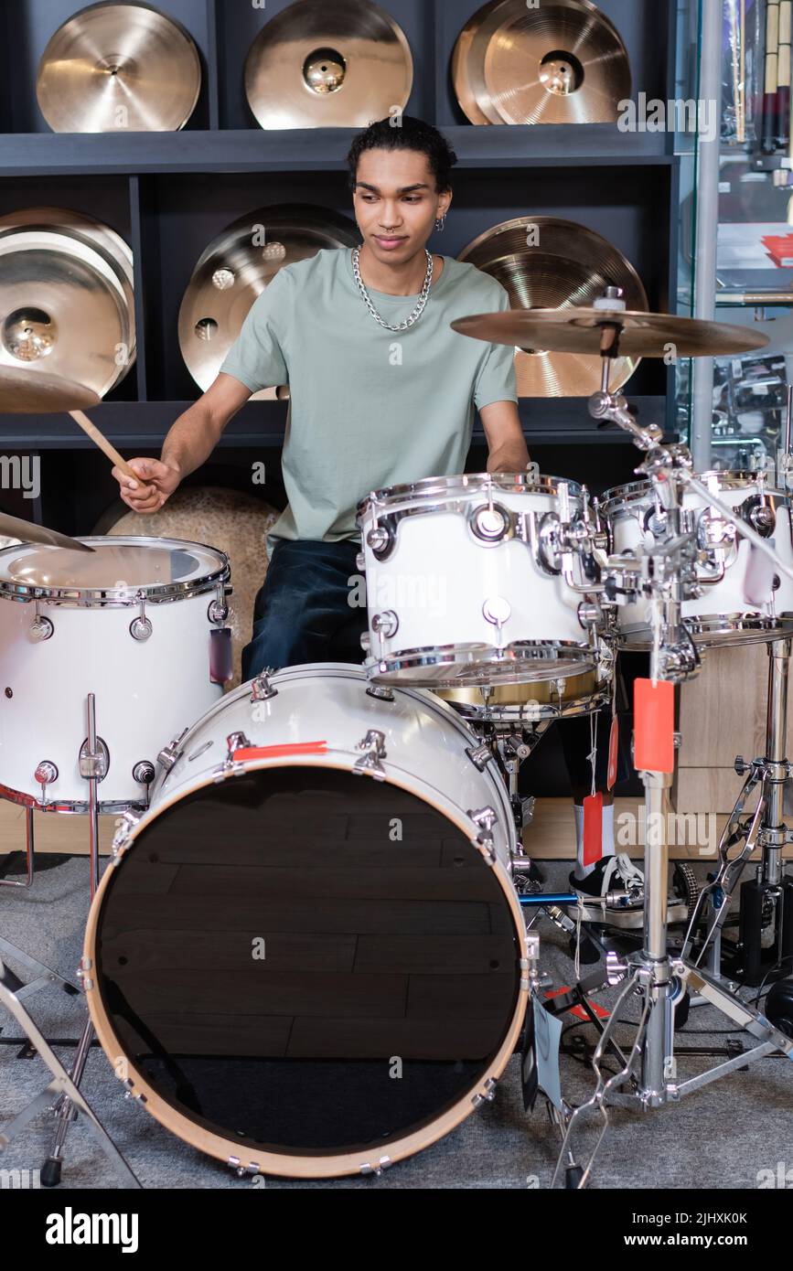 African american customer playing drums in music store Stock Photo - Alamy