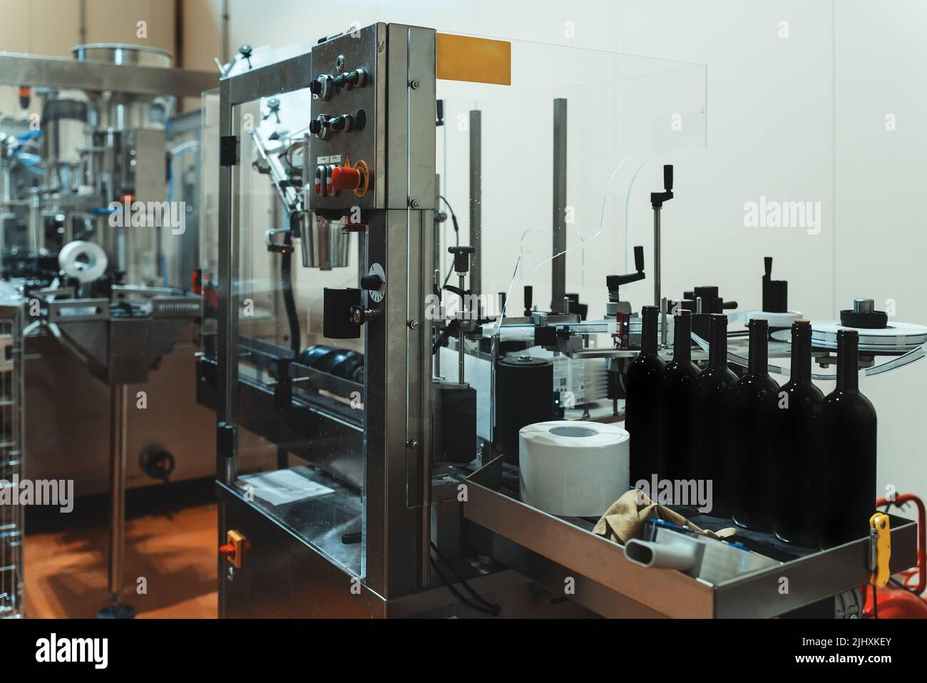 Automatic line for bottle labeling at wine factory Stock Photo - Alamy