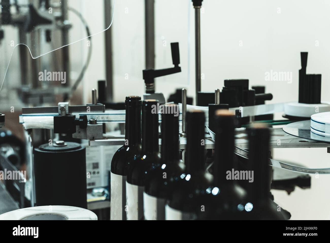Automatic line for bottle labeling at wine factory Stock Photo - Alamy