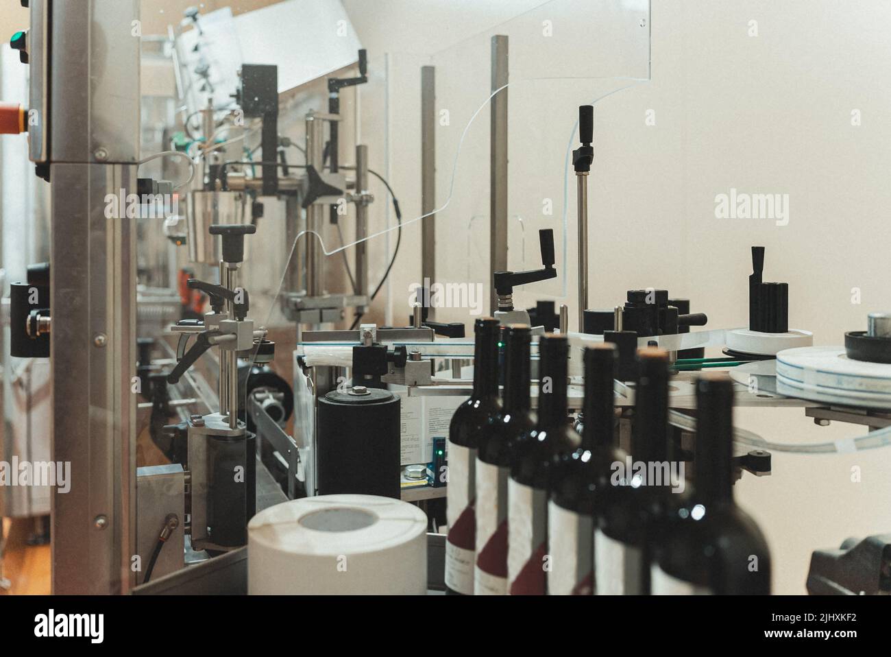 Automatic line for bottle labeling at wine factory Stock Photo - Alamy