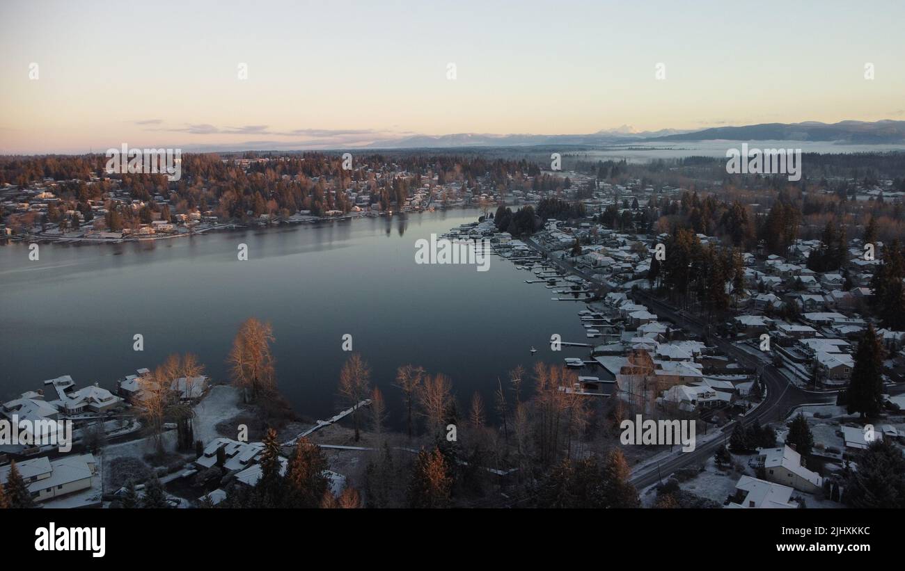 An aerial drone view of Lake Stevens surrounded by trees and houses in ...