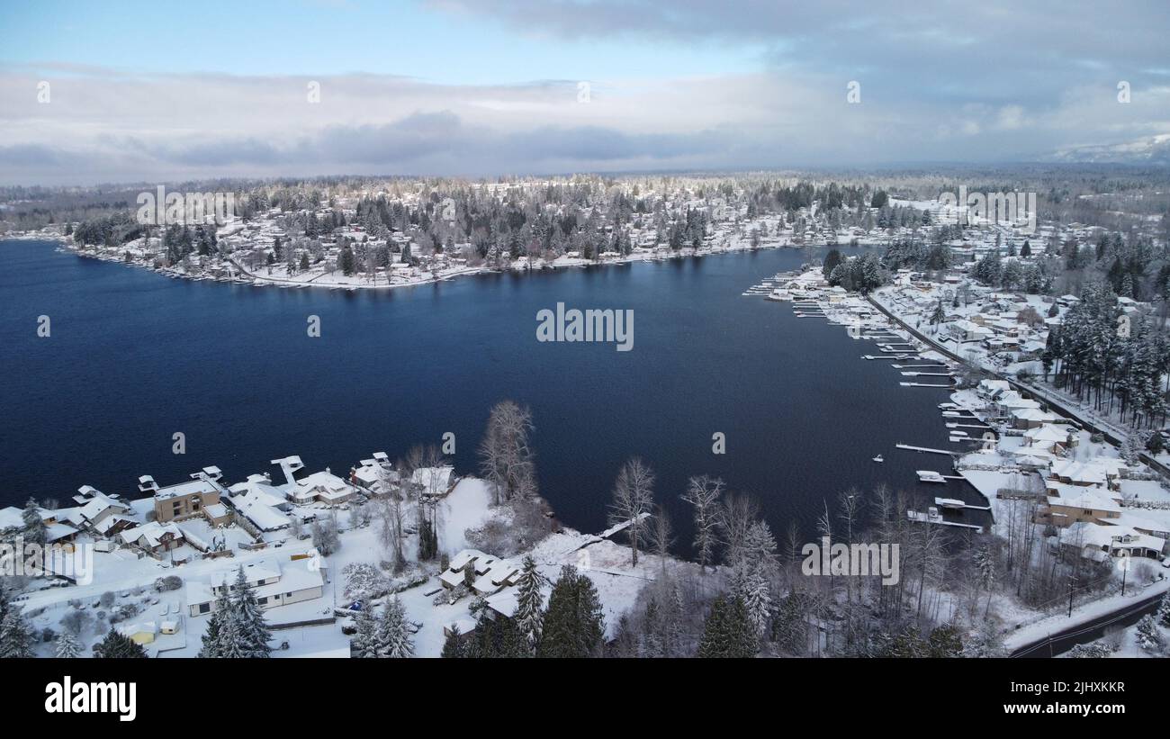 An aerial drone view of Lake Stevens surrounded by trees and houses ...
