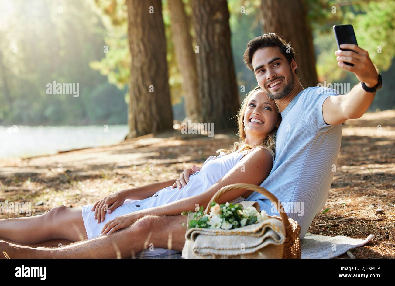 Lets take a selfie to save the date. a couple taking a selfie while on ...