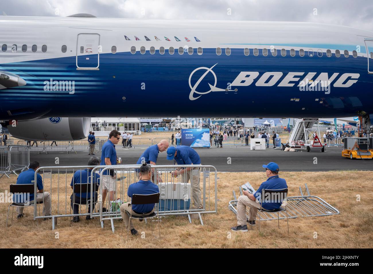 Boeing workers are beneath a Boeing 777X at the Farnborough Airshow, on ...