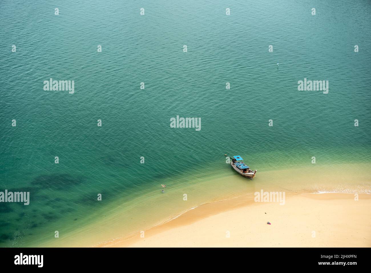 An aerial view of a boat on the beach in the green ocean water Stock ...