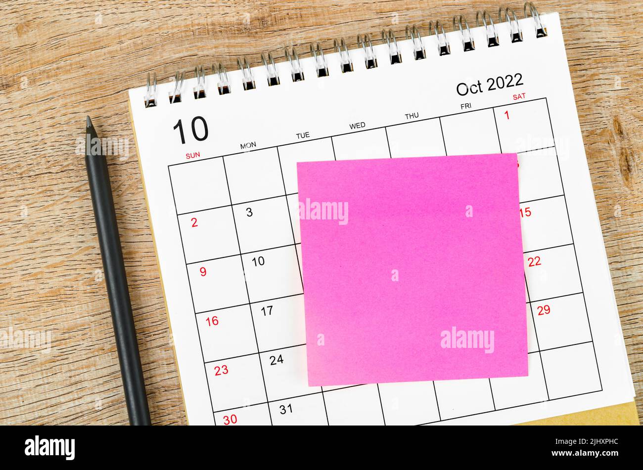 Blank sticky note on October 2022 desk calendar on wooden background ...