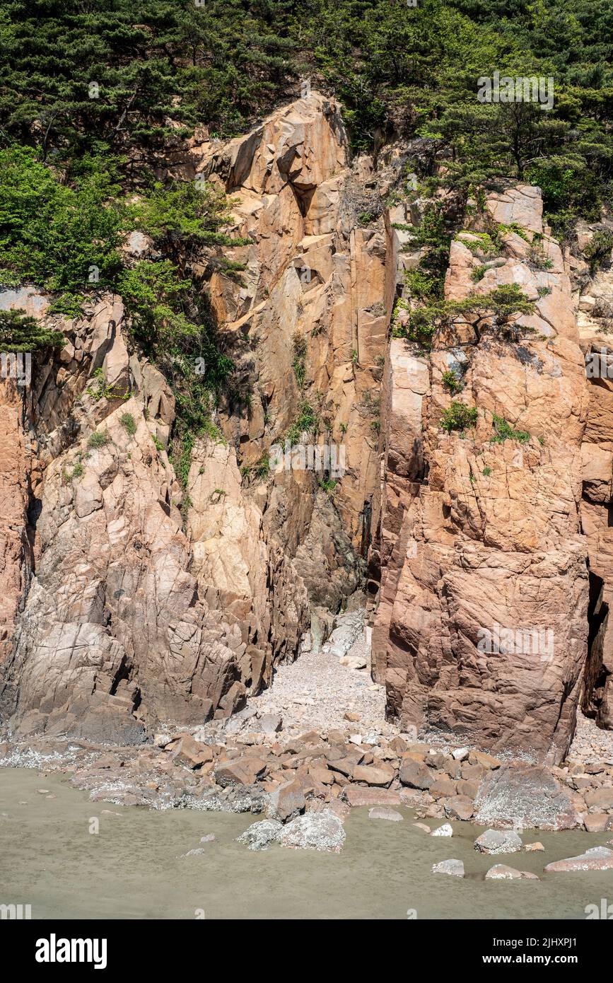 A vertical shot of big rock formations on the ocean coast Stock Photo ...
