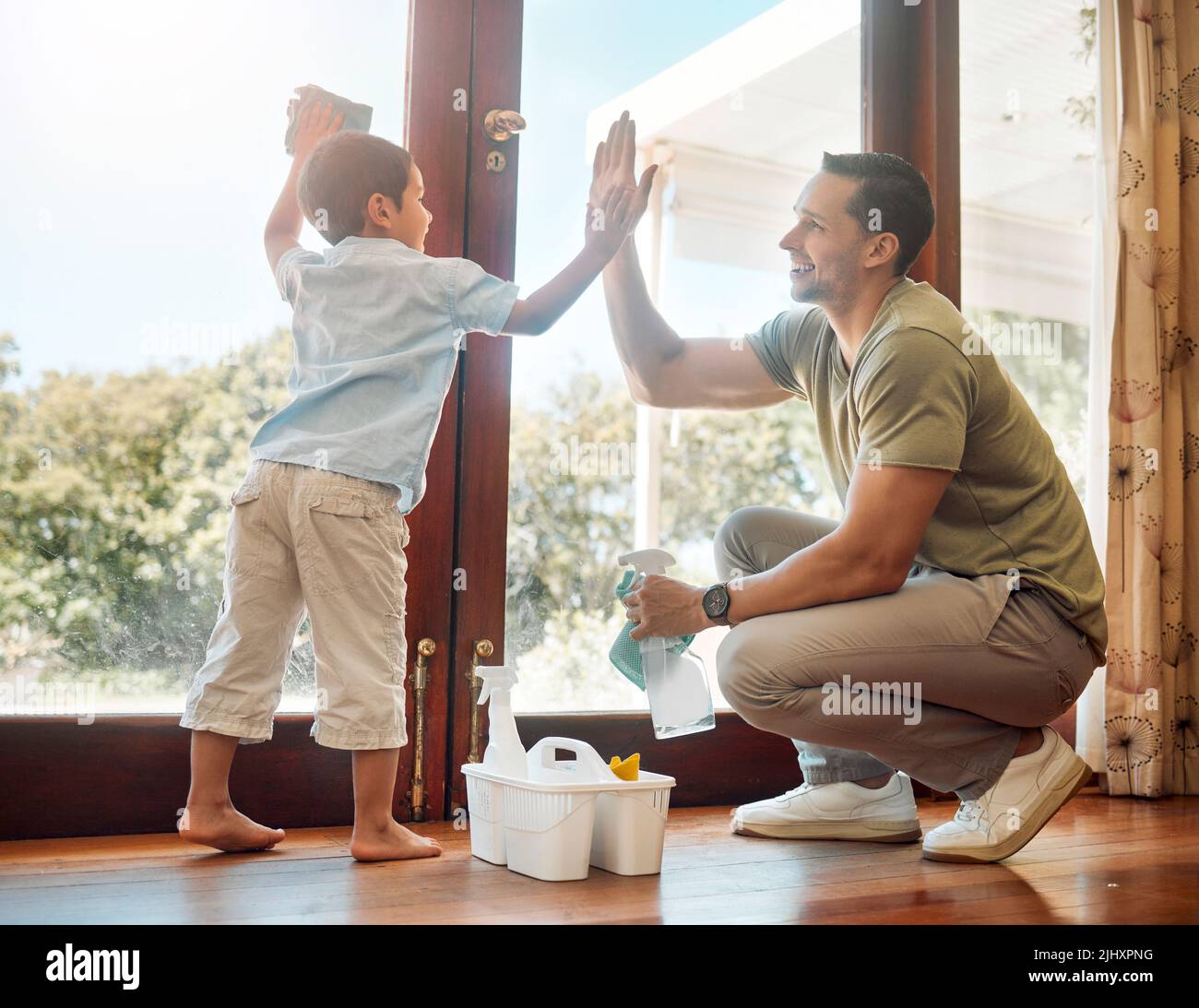 Young happy mixed race father and son giving each other a high five ...