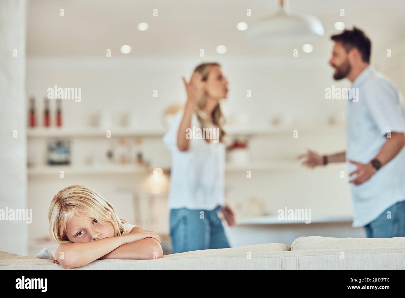 Portrait of sad little girl, parents fighting in the background ...