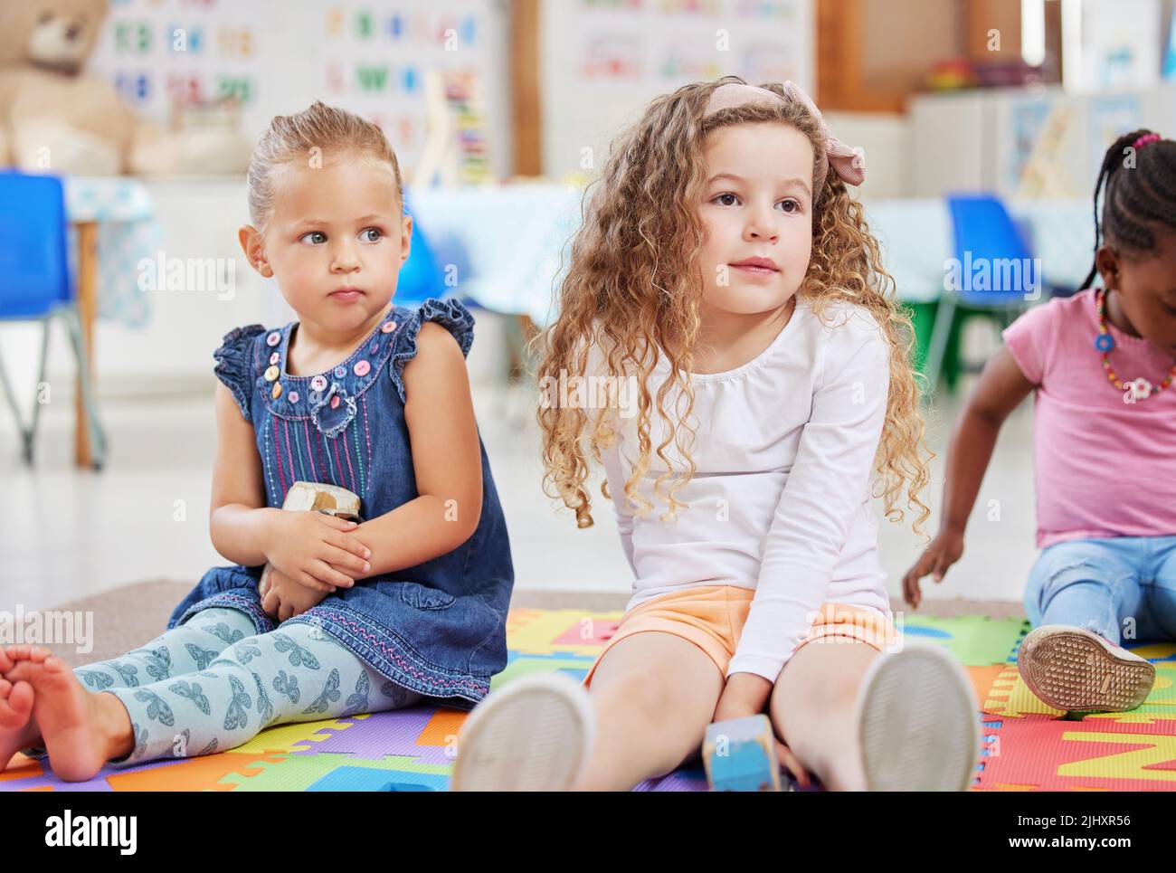 Paying attention in class. two little girls sitting next to each other ...
