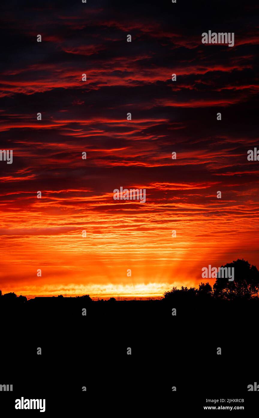 Red sunset over the Dutch countryside. Textured clouds are illuminated ...