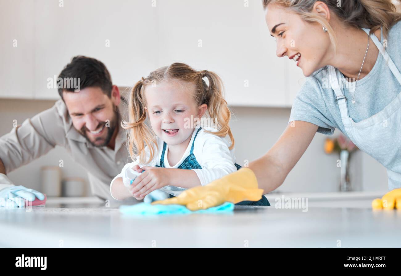 Little girl helping her parents clean. Caucasian family cleaning their ...