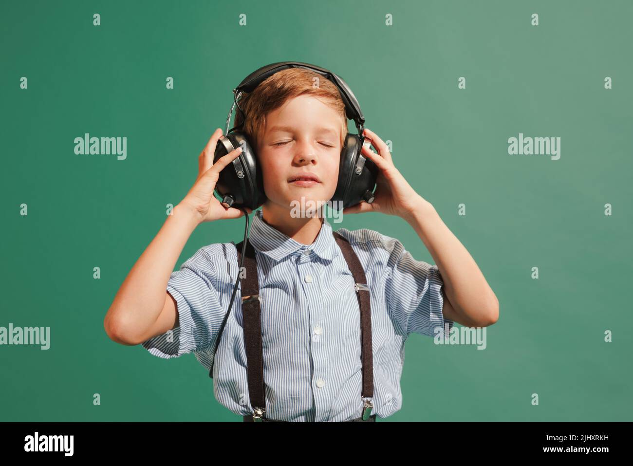 One preschool boy, kid wearing retro style outfit isolated on dark ...