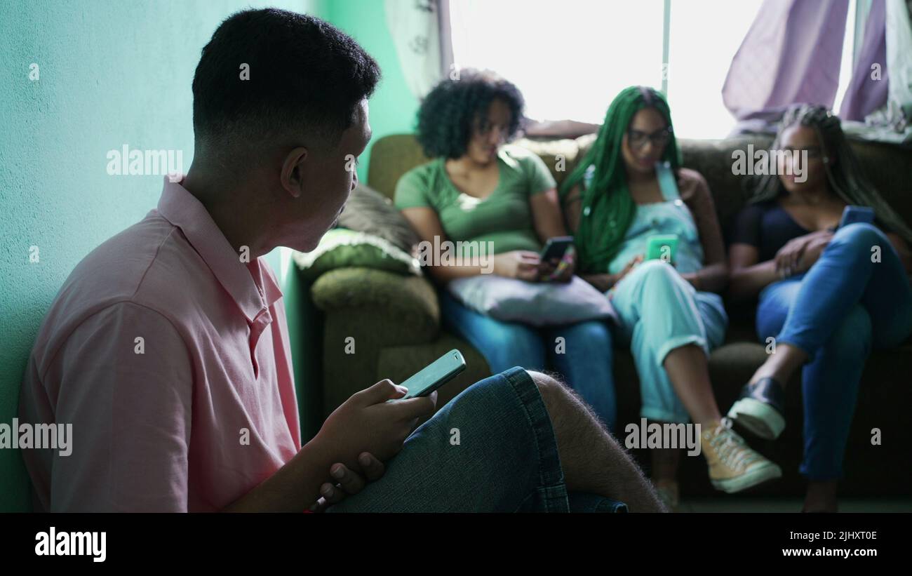 Candid group of friends staring at phones living in isolation bubbles ...