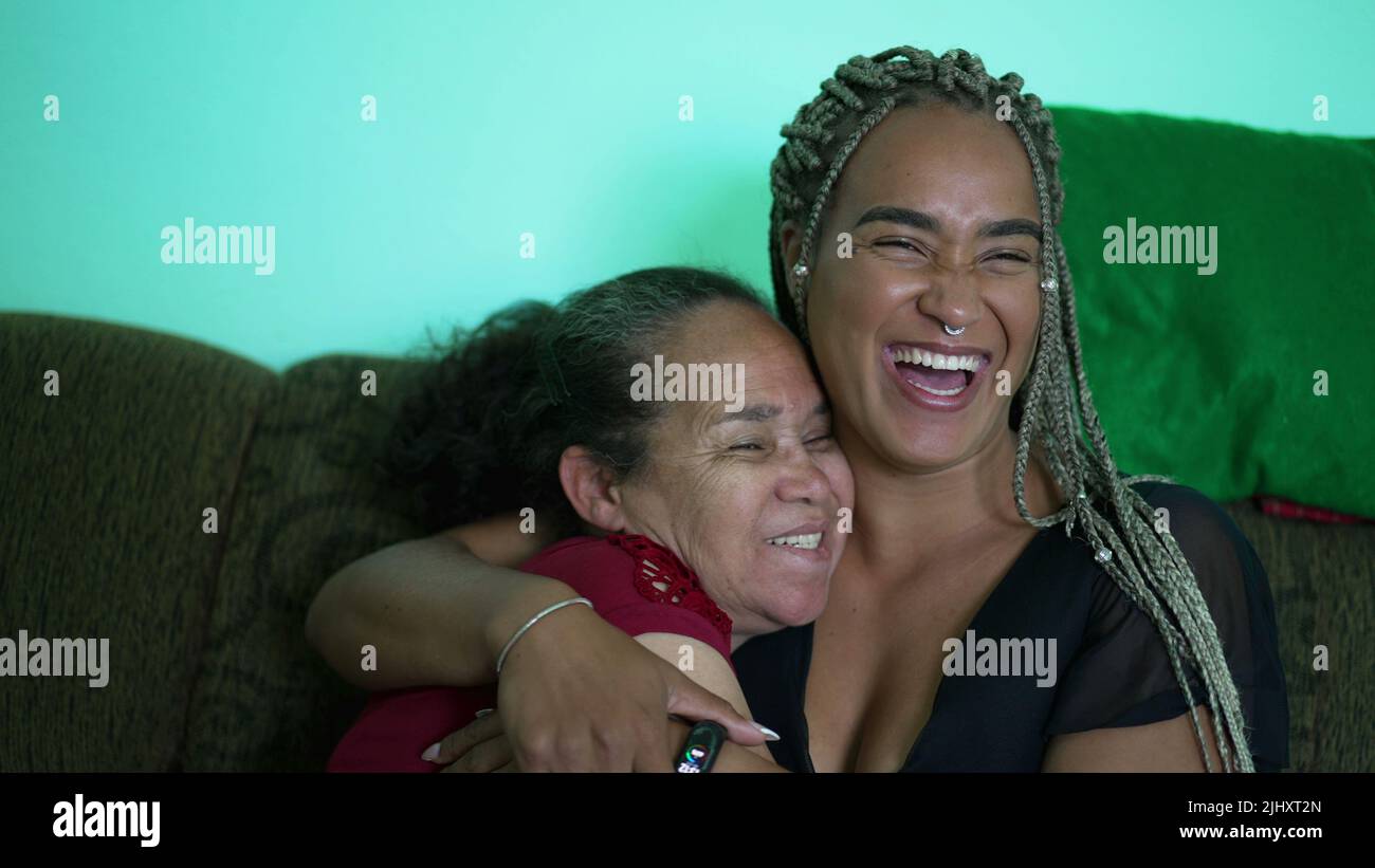 Mother and daughter laughing and smiling together. Two hispanic south ...