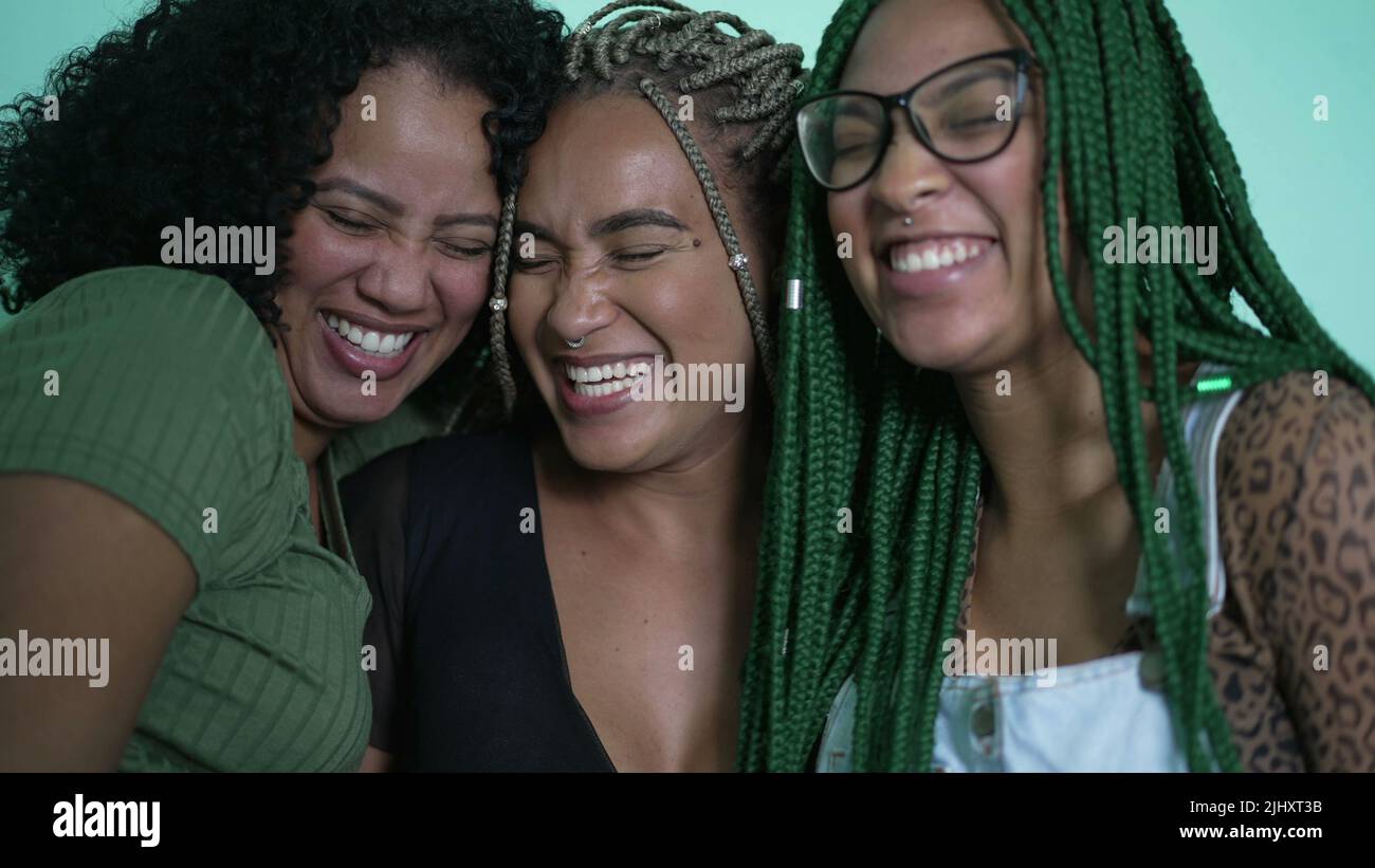 Happy female friends embrace. Three happy black African women laughing ...