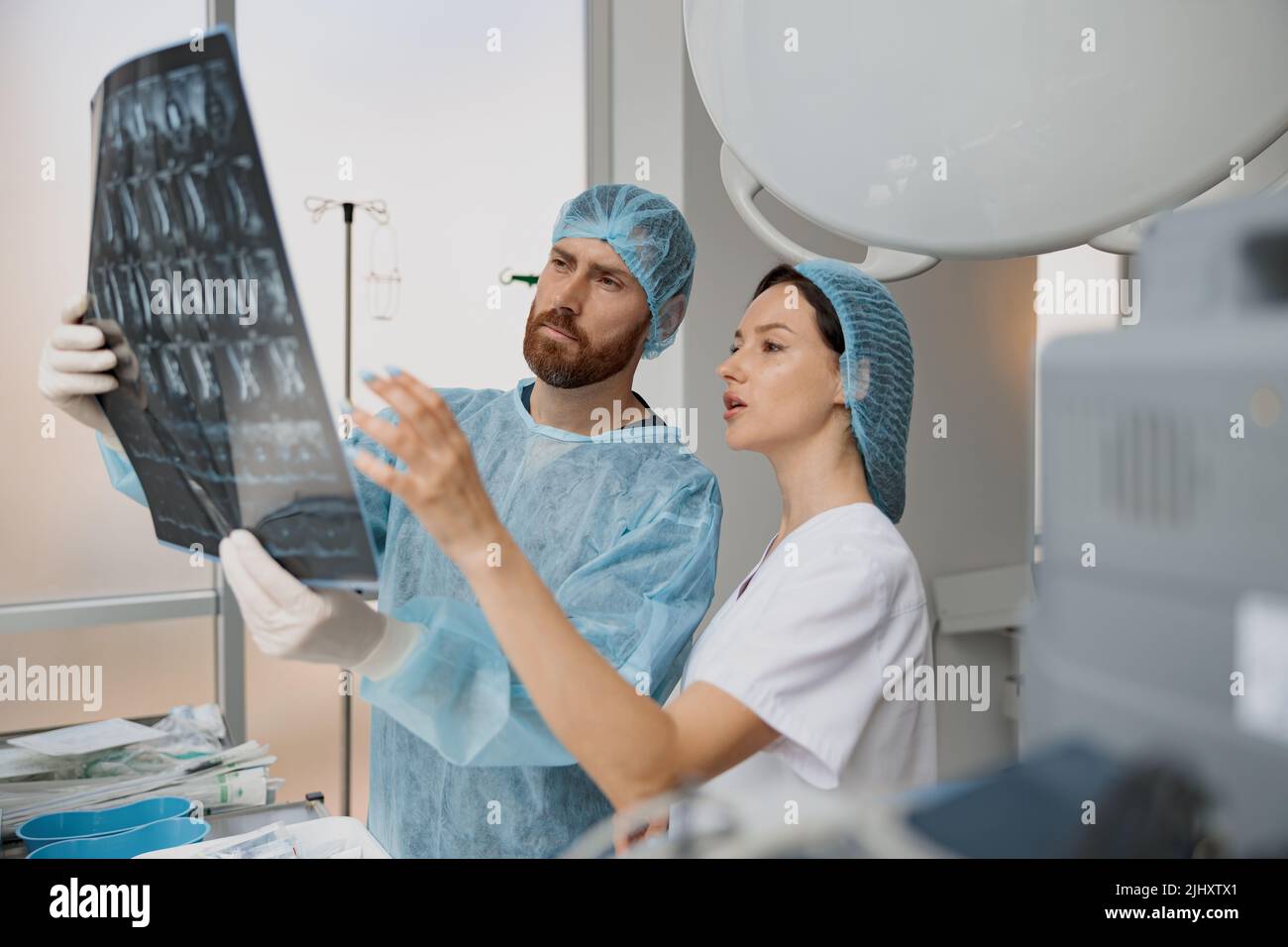 Two doctors in uniform look and discuss an X-ray or MRI scan of the ...