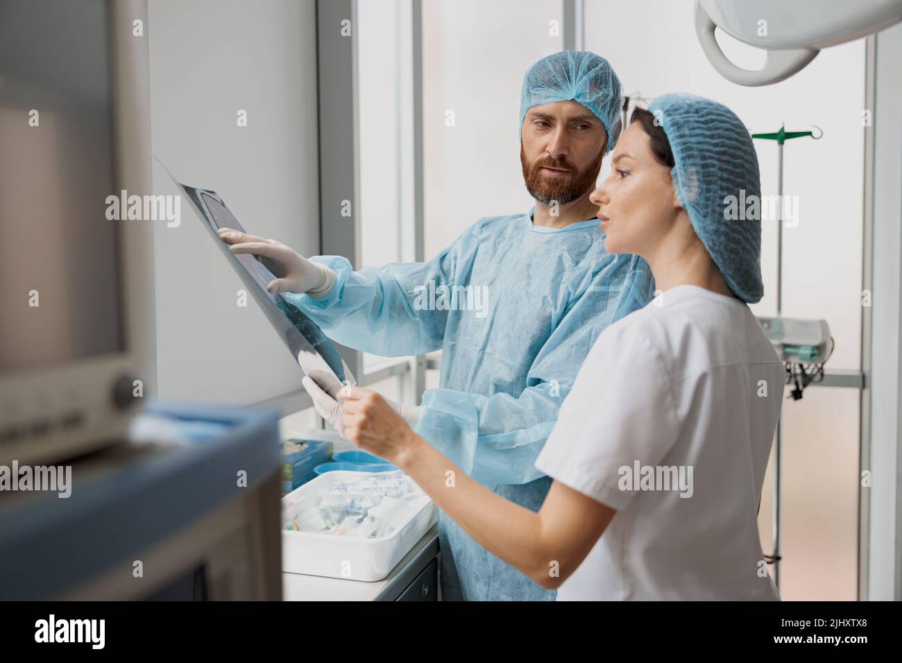 Two doctors in uniform look and discuss an X-ray or MRI scan of the ...
