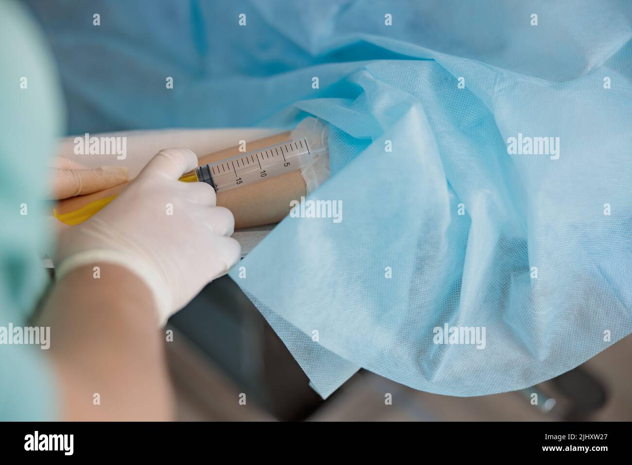 Hands of the doctor anesthesiologist makes an injection for pain before ...