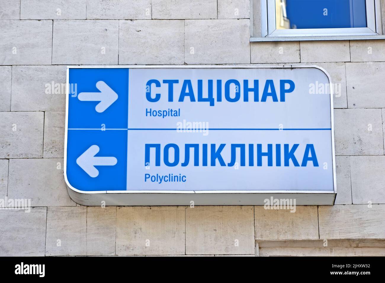 hospital and polyclinic arrow direction signboard on stone wall, modern ...