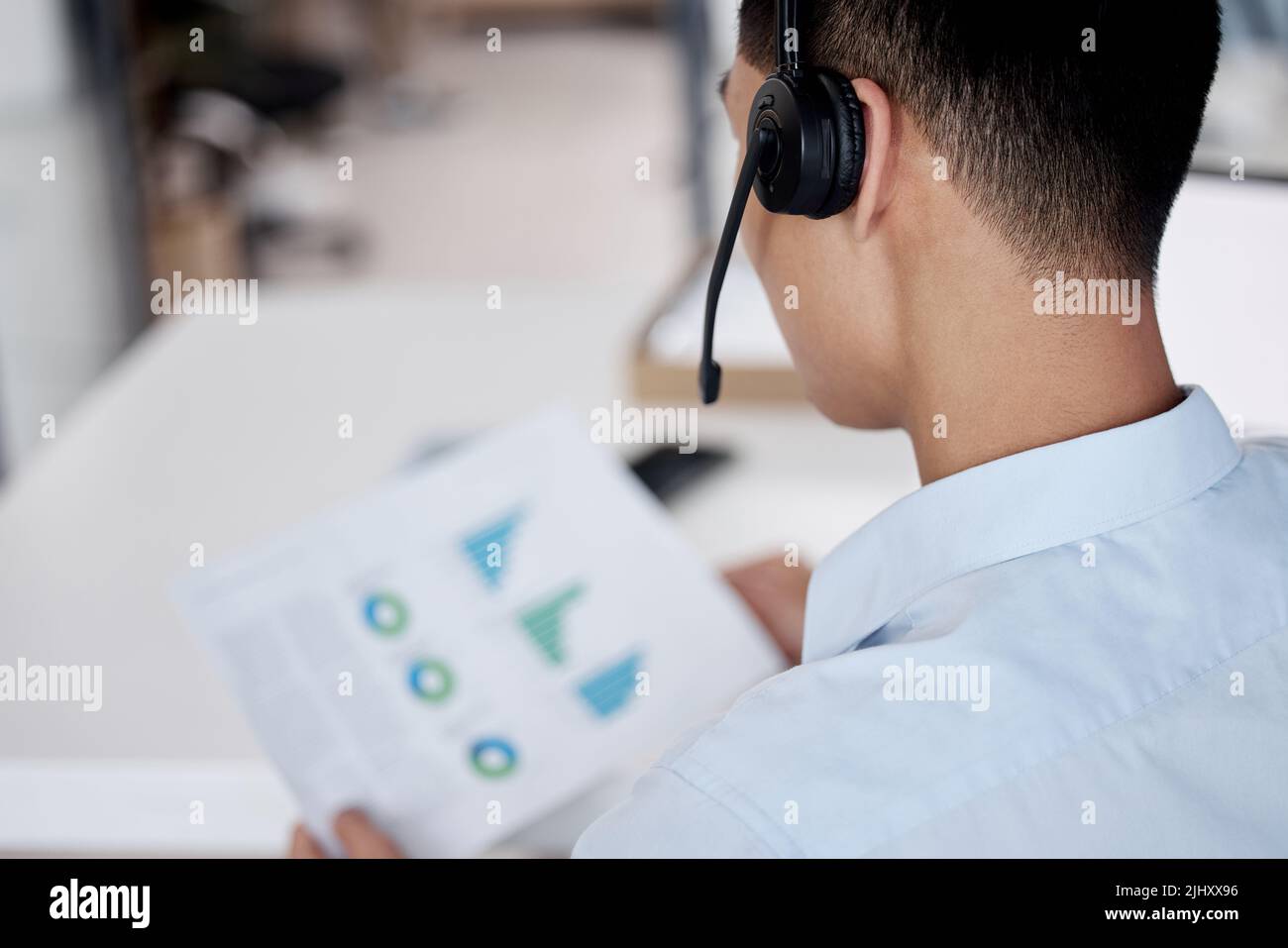 Businessman working in a call center reading a document. Call center ...