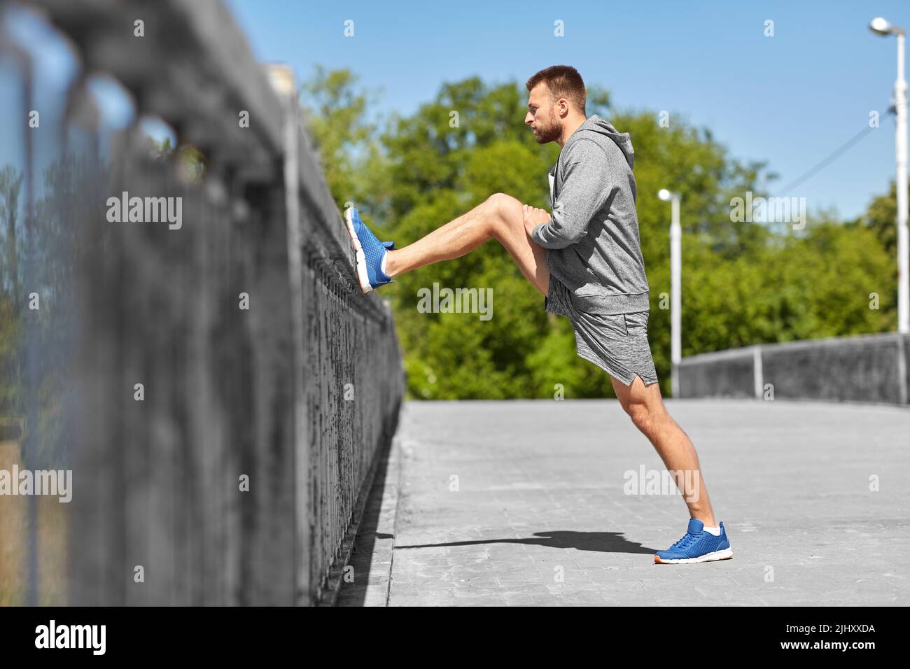 man stretching leg on bridge Stock Photo - Alamy