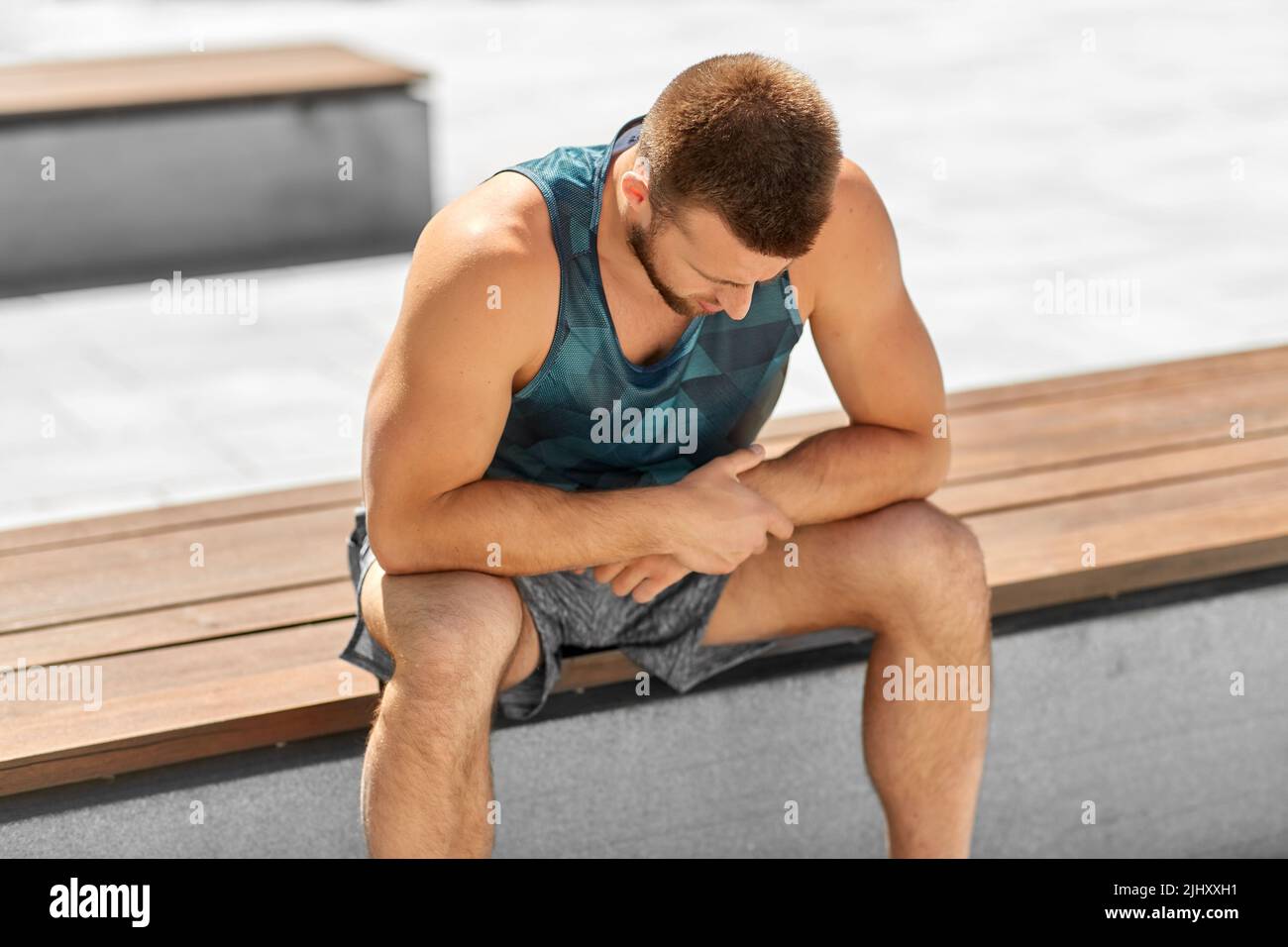 young man sitting on bench outdoors Stock Photo - Alamy