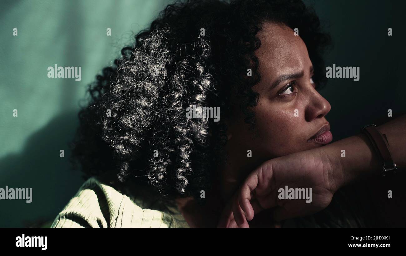 One depressed black woman at home. A concerned African girl sad ...