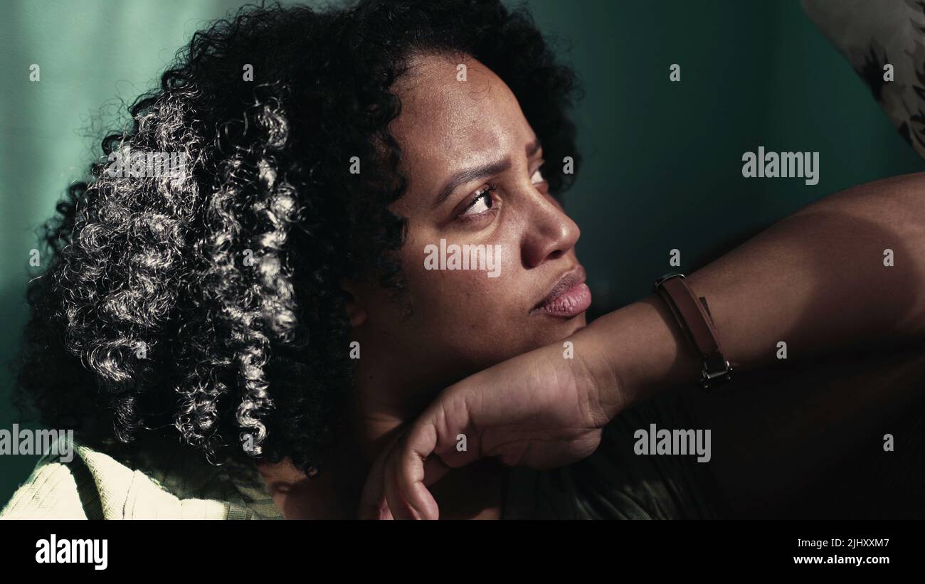 One depressed black woman at home. A concerned African girl sad ...