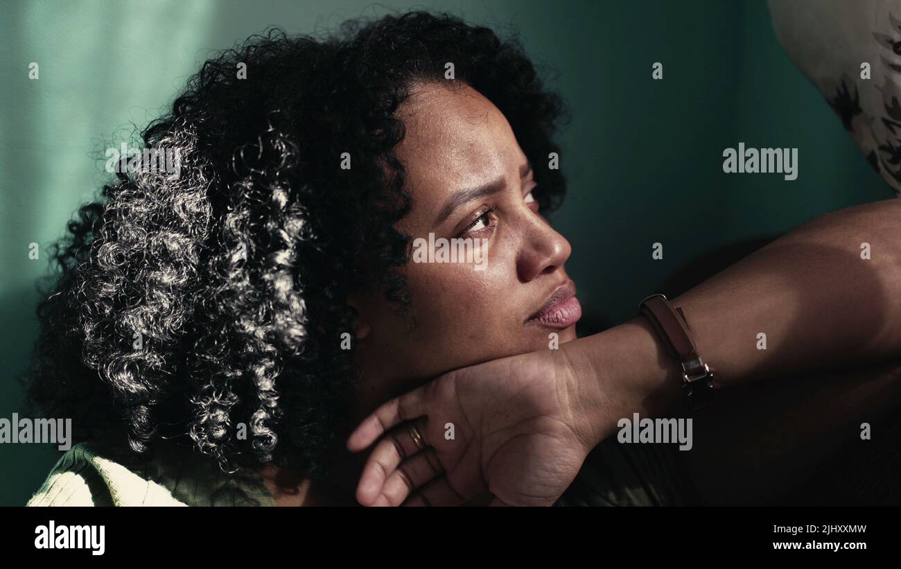 One depressed black woman at home. A concerned African girl sad ...