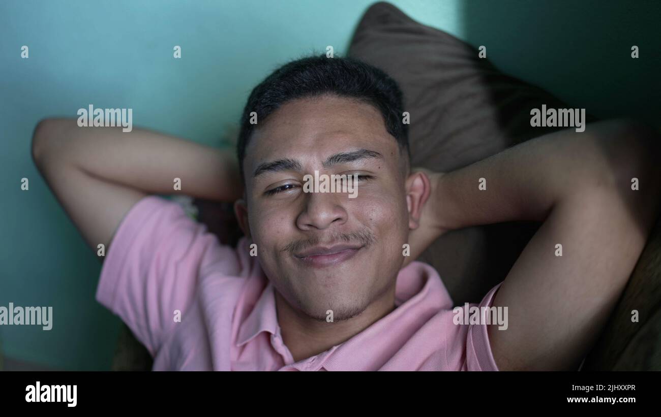 One happy hispanic man lying on couch relaxing. Confident person ...