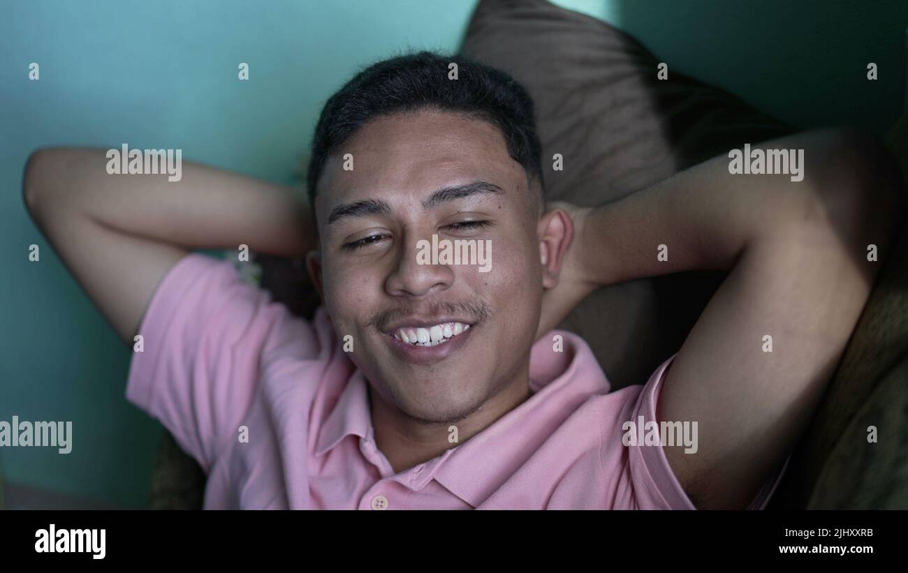 One happy hispanic man lying on couch relaxing. Confident person ...