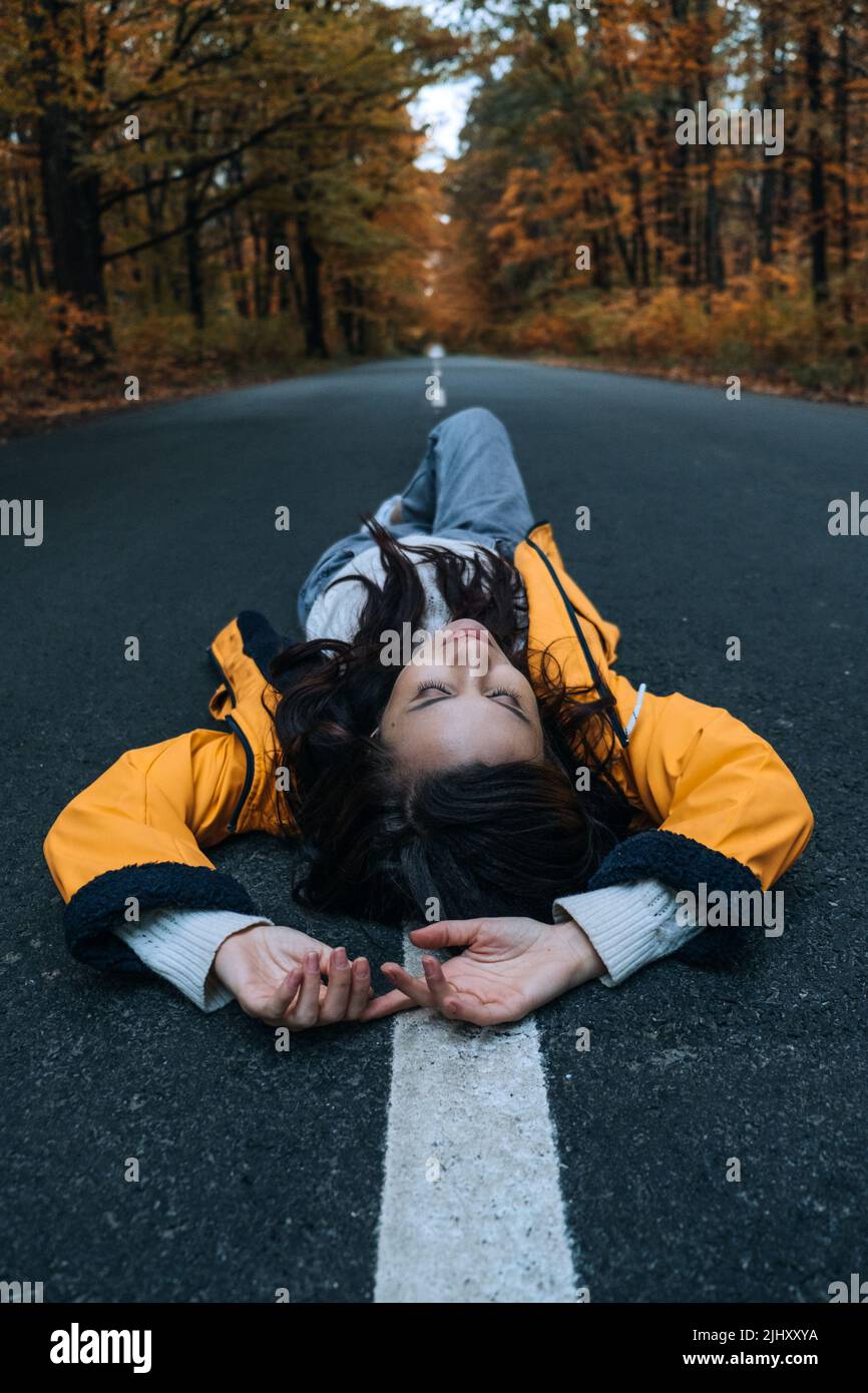 Confidence woman lying on the road with autumn tree around. New life ...